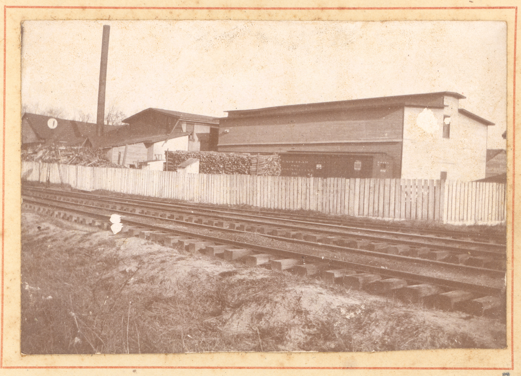 Railroad Tracks Running by a Fence