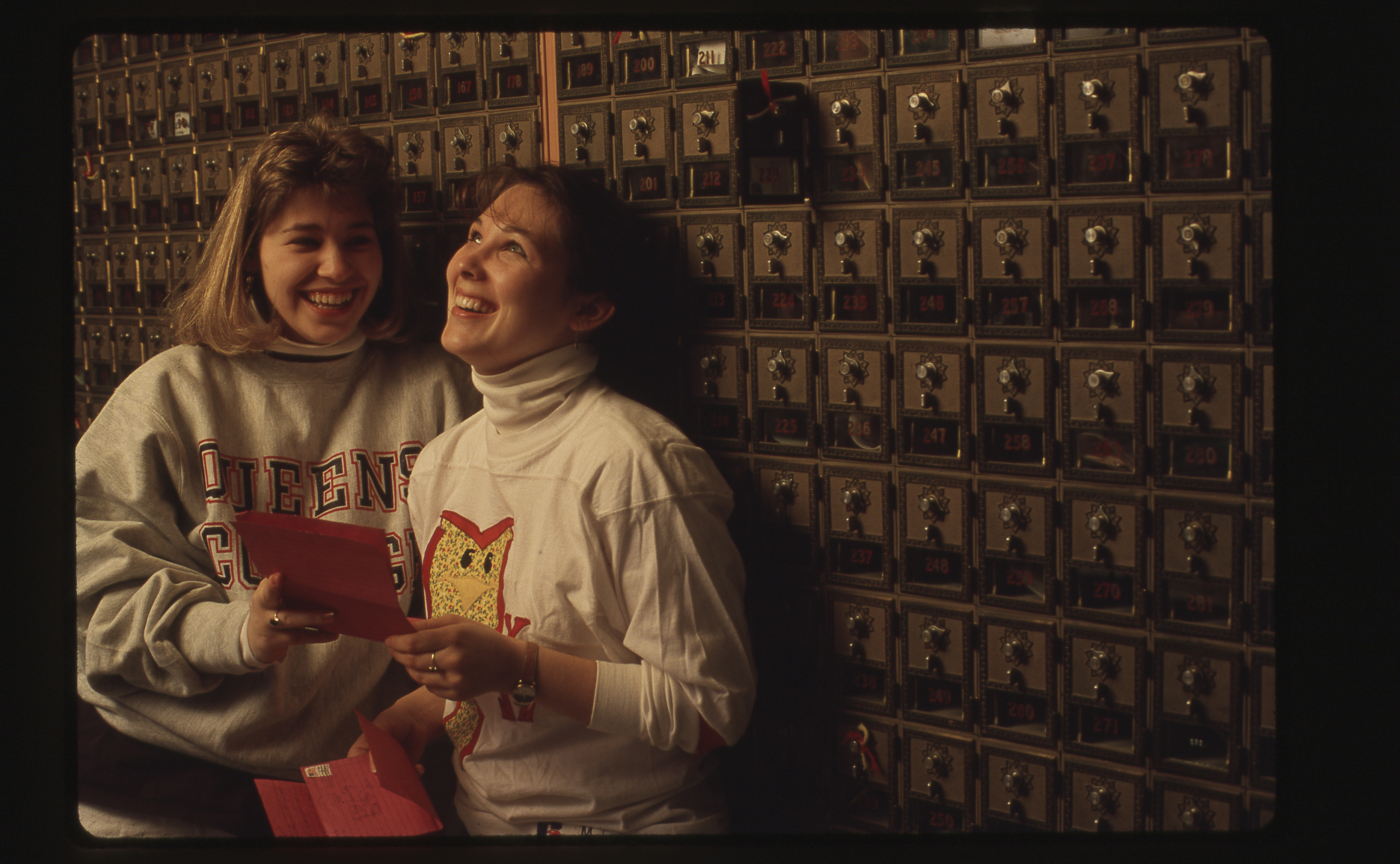 Two students standing next to student mail boxes at Queens College
