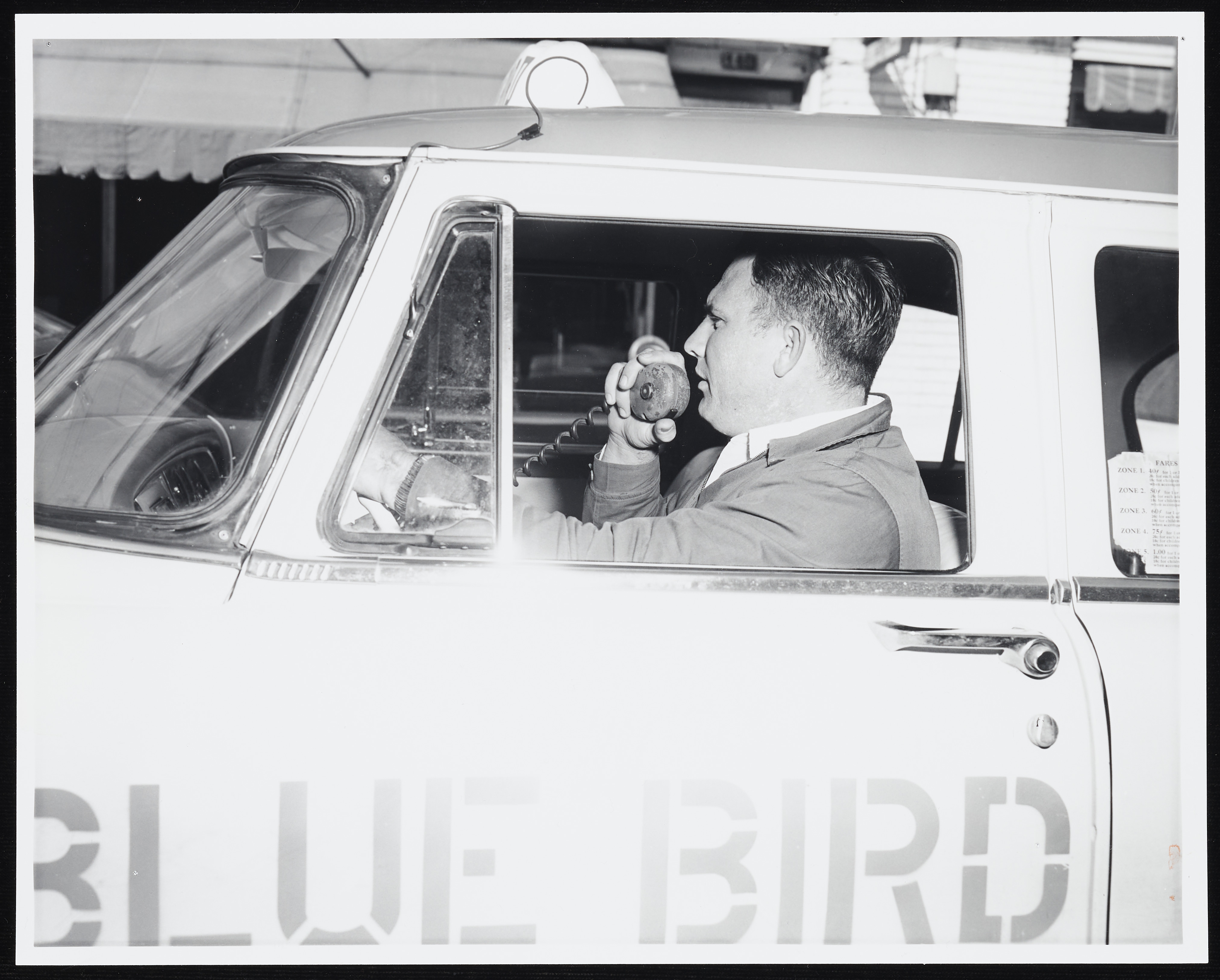 Adult Talking on a Walkie-Talkie in a Blue Bird Taxi
